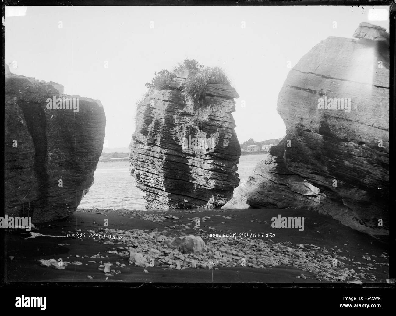 This photograph, taken by Gilmour in 1910, depicts Houa Rock at Raglan ...