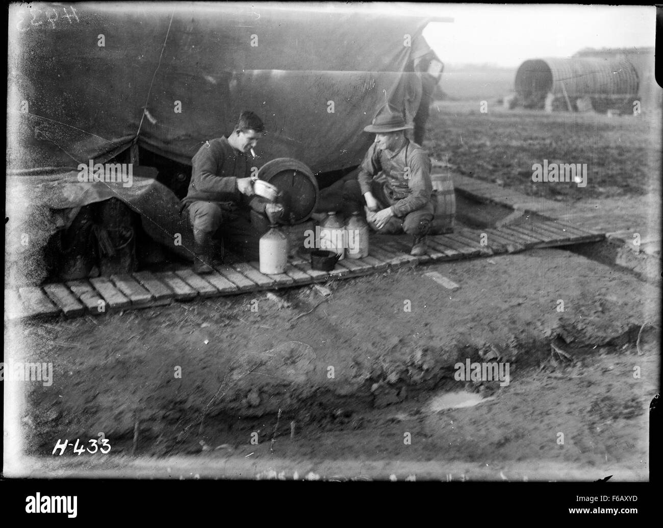 This historical photograph shows soldiers receiving their rum rations ...