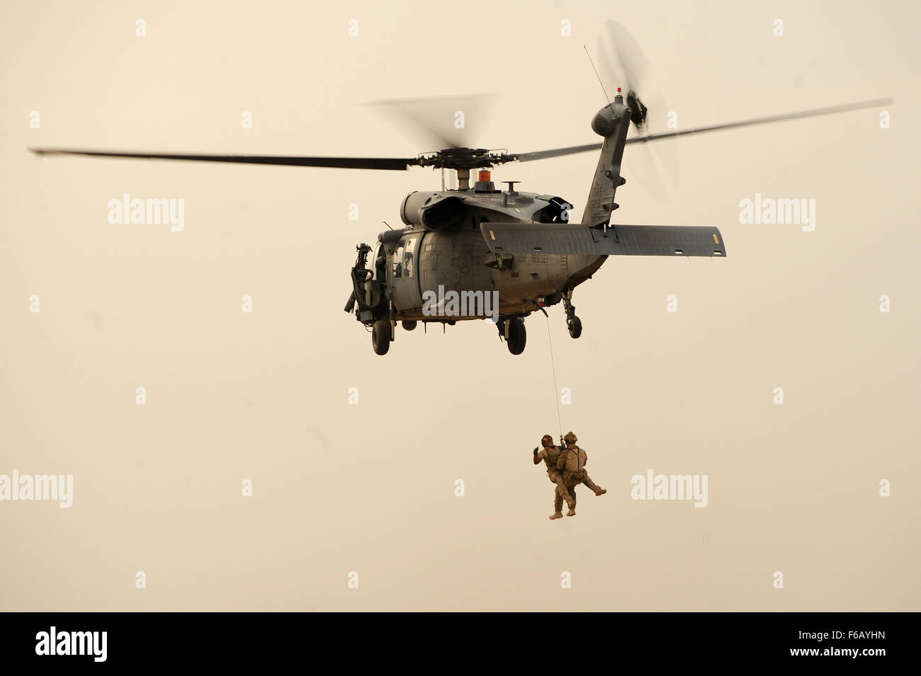 U.S. Air Force pararescuemen are hoisted into an HH-60G Pave Hawk helicopter during training at ...