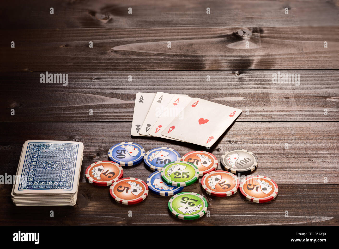 Four aces and chips, vintage poker game playing cards on a wood table ...