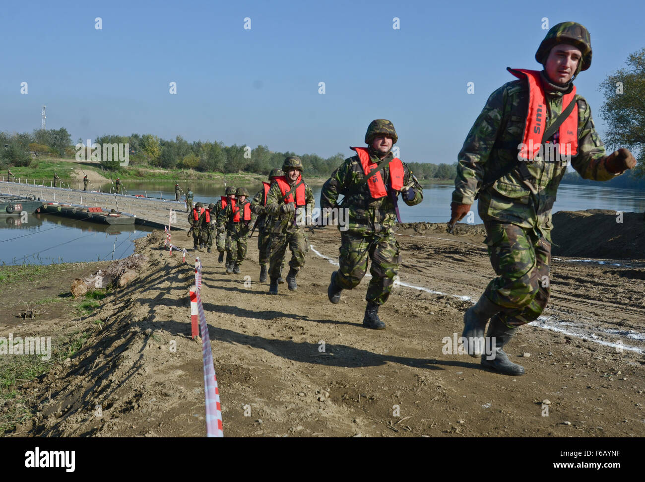 Romanian Soldiers run up the hill in a single file near the Mures River ...