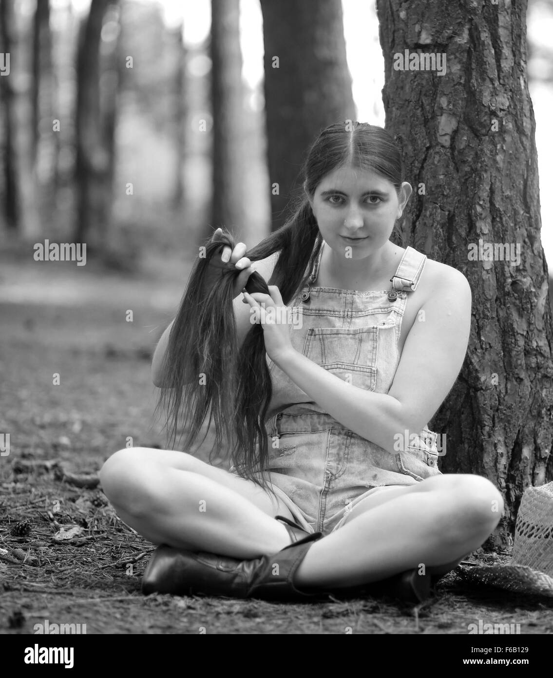 Country backwoods girl in old cut dungaree shorts in the woods, July ...