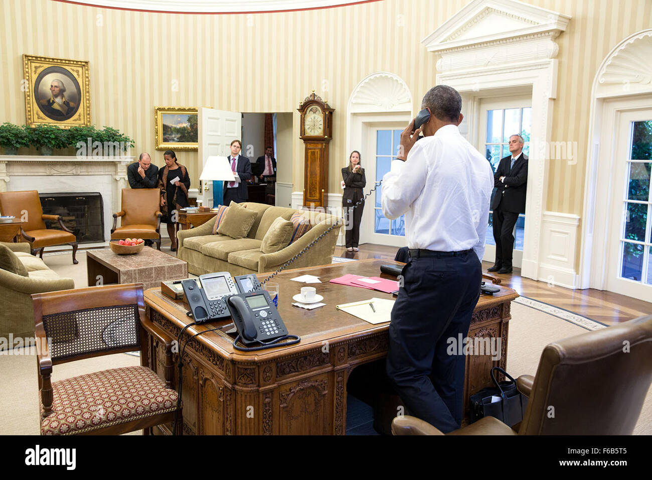 President Barack Obama talks on the phone in the Oval Office with ...