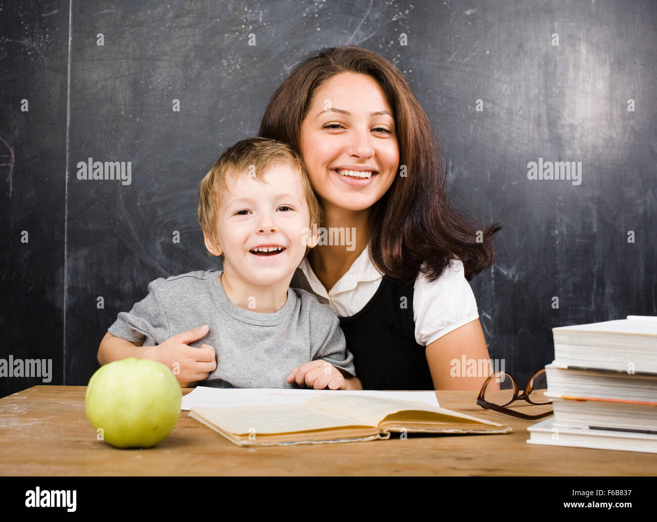 little cute boy with young teacher in classroom studying Stock Photo ...