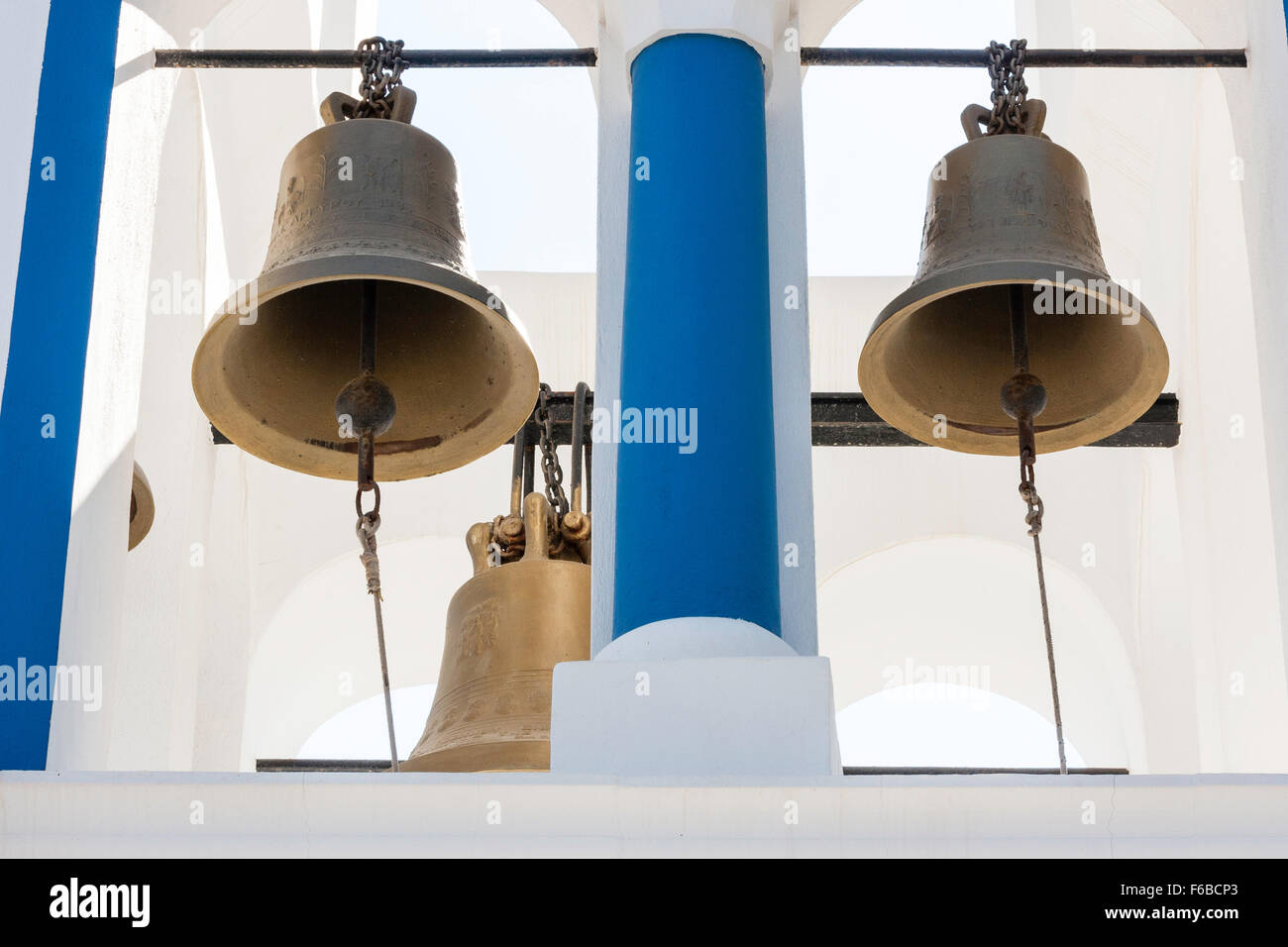 Cyclades, Santorini, Thira. Close up of three bronze bells in ...