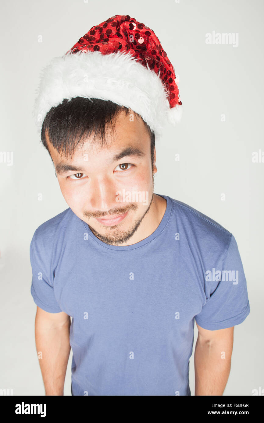 funy exotical asian Santa claus in new years red hat smiling Stock ...