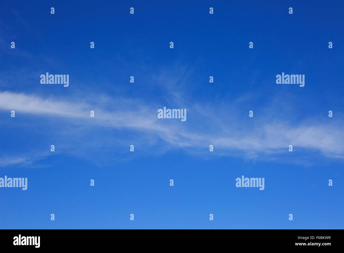 Aircraft contrail blown to a featherly texture by upper level winds ...