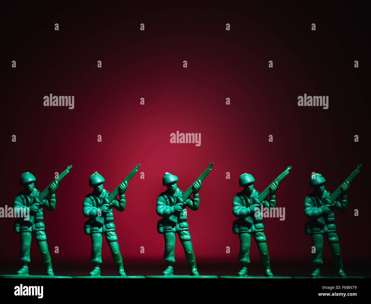 Several plastic soldiers in row, red background Stock Photo - Alamy