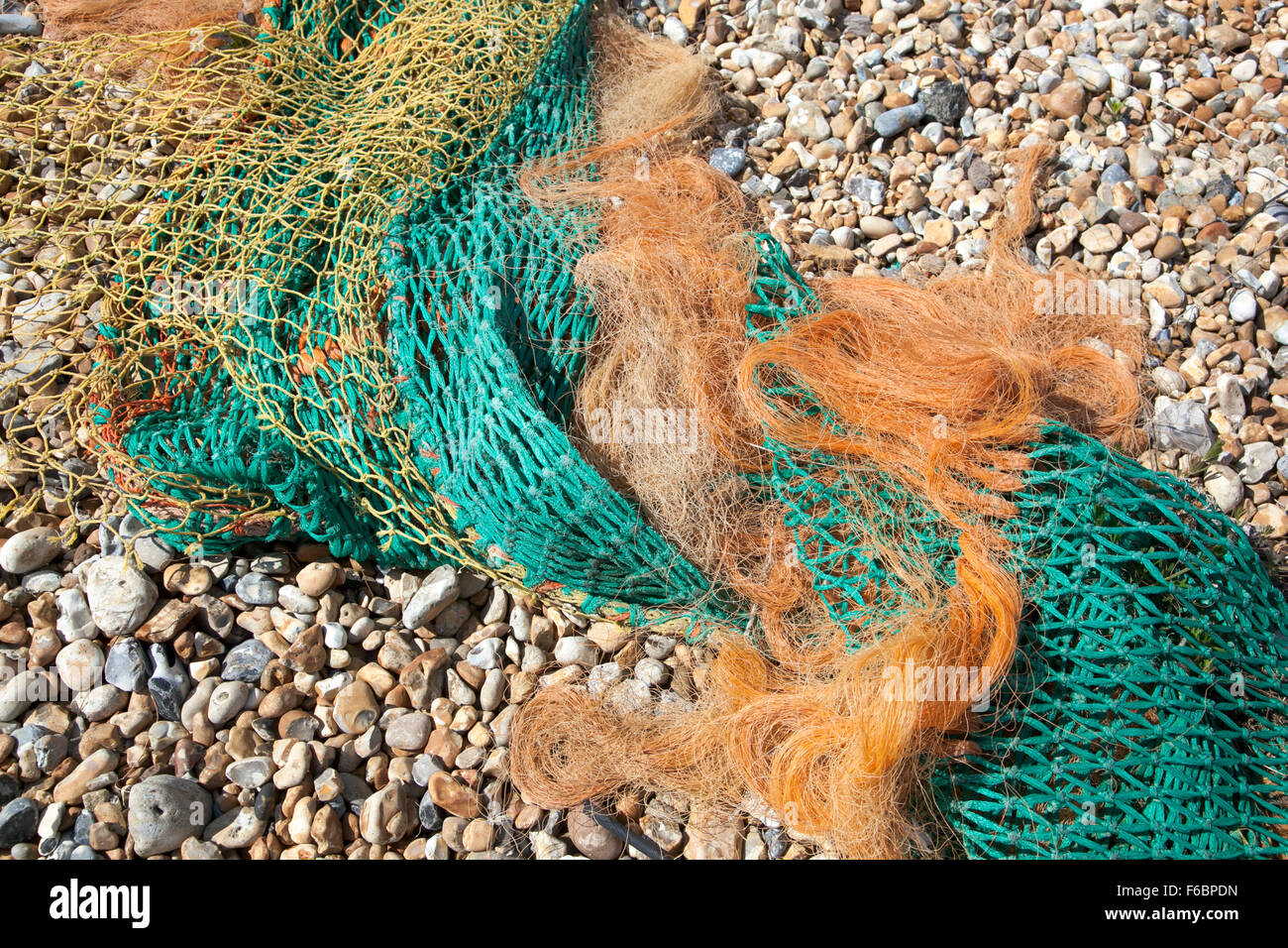 Tangled, colourful fishing nets on a pebble beach Stock Photo - Alamy