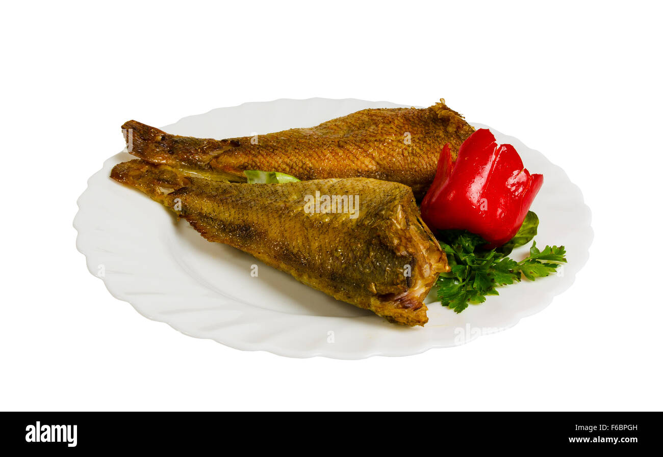 grilled fish with greens on the plate, isolated on white background ...