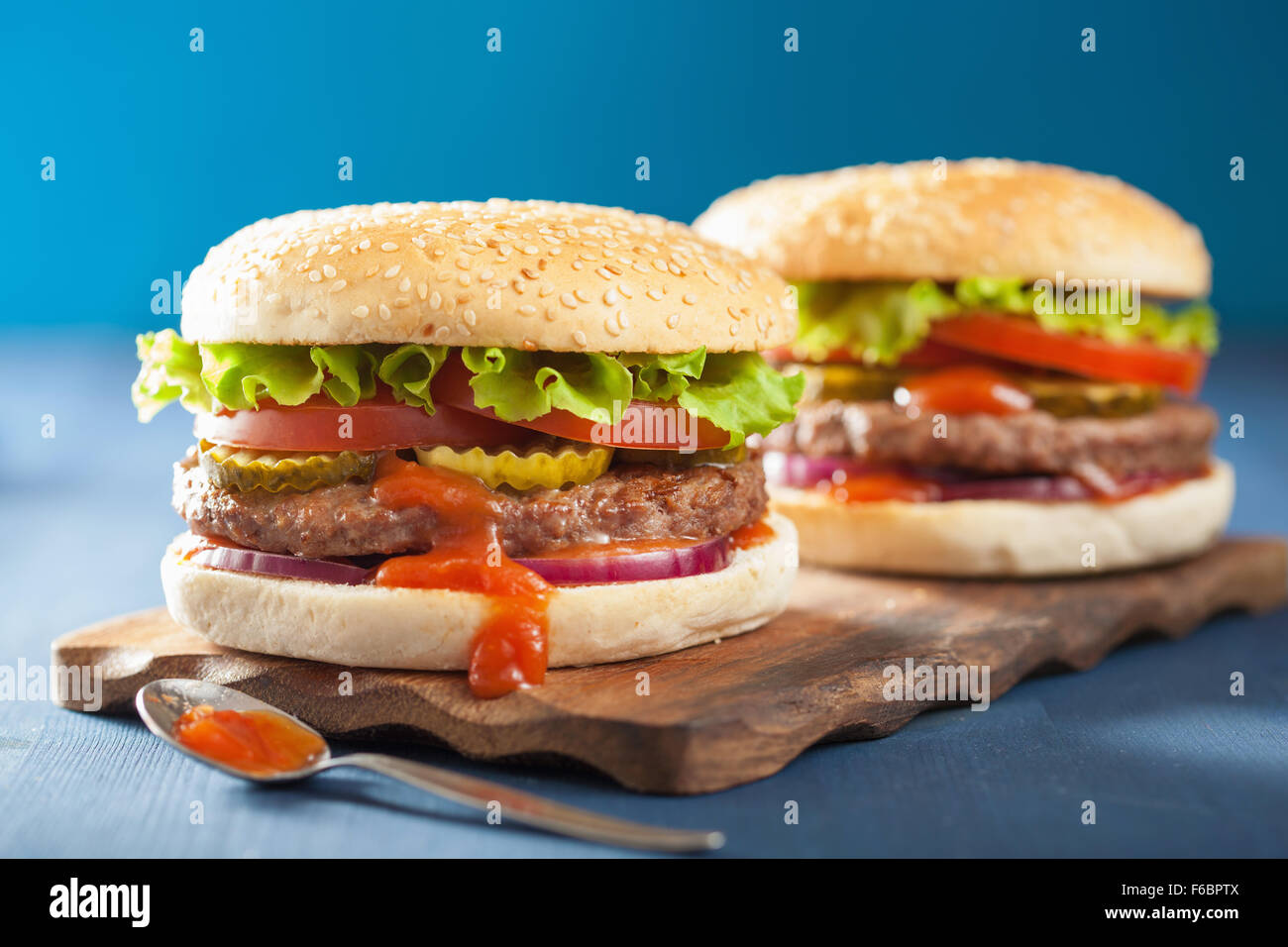 burger with beef patty lettuce onion tomato ketchup Stock Photo - Alamy