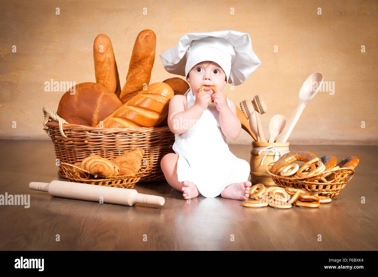Little cook. Small kid in a chef's hat with wicker baskets of pastries ...