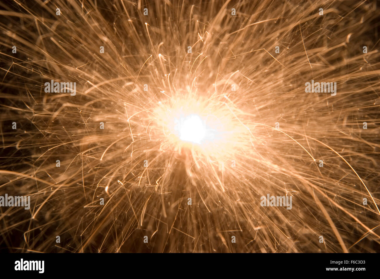 Sparks from a sparkler radiate outwards from the central core of the ...