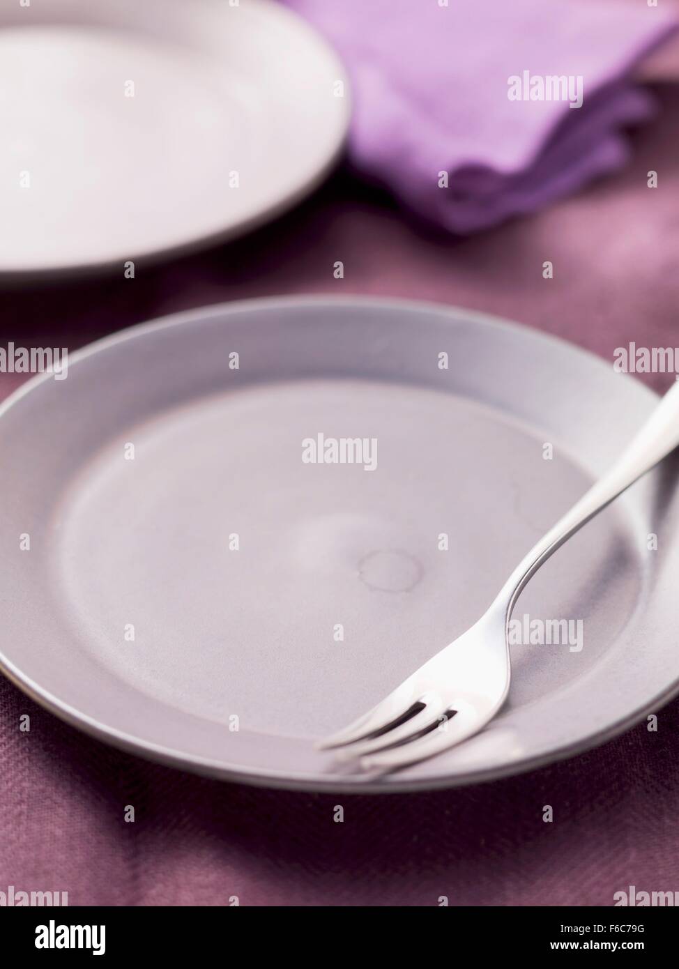 An empty plate with a dessert fork Stock Photo - Alamy