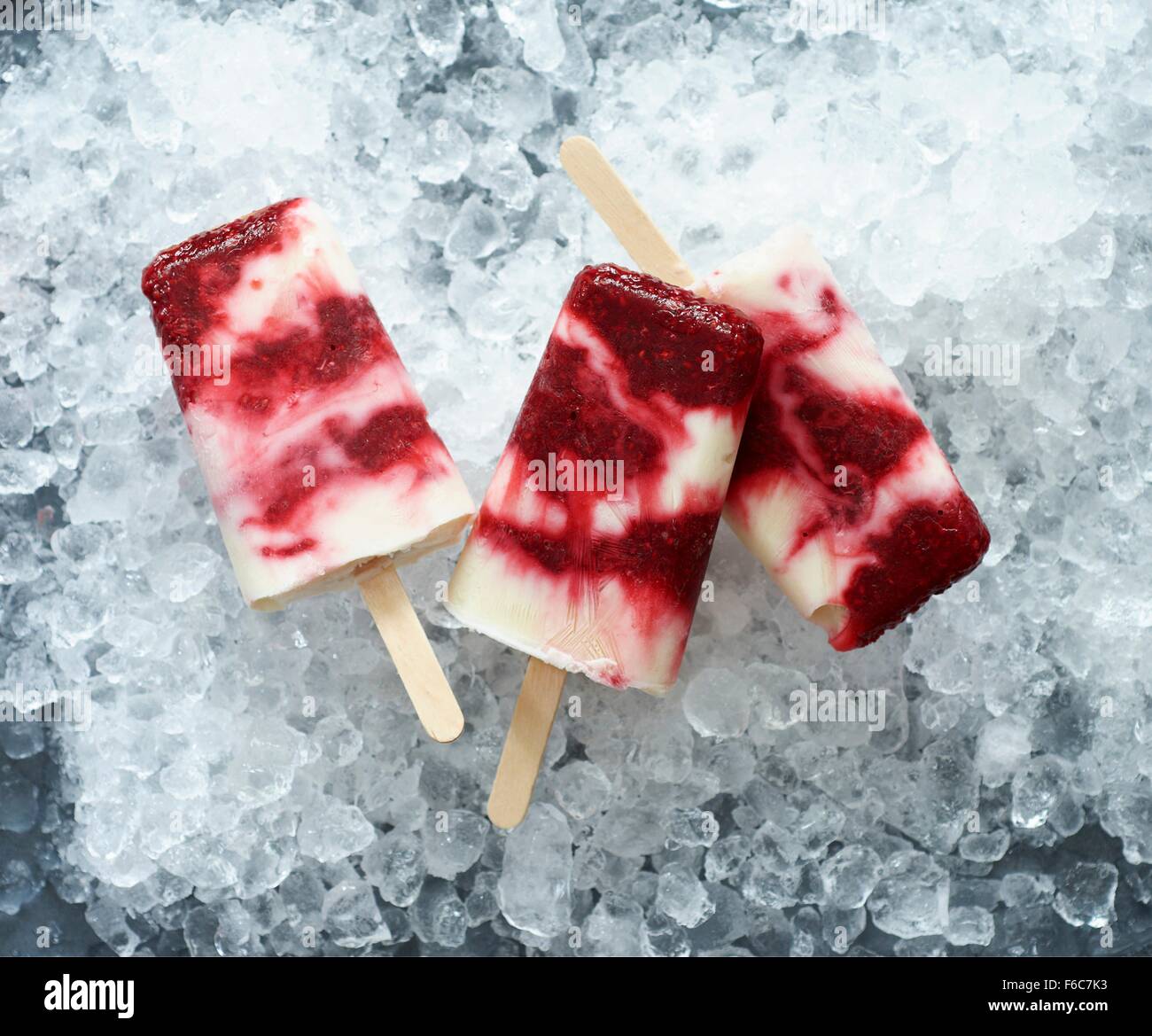 Ice lollies (raspberry and vanilla) on ice cubes Stock Photo - Alamy