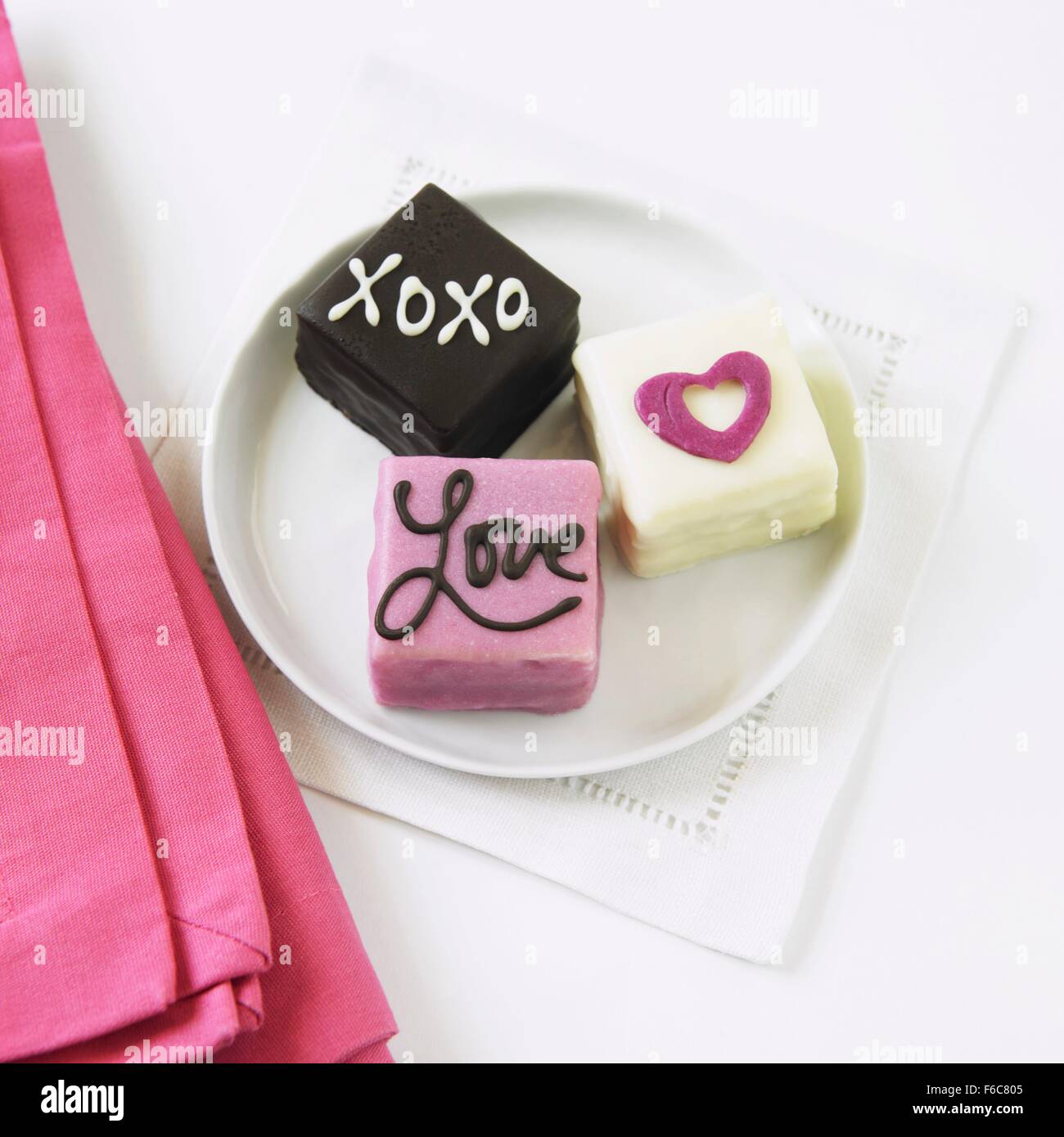 Three Assorted Mini One-Bite Valentine Cakes on a White Plate Stock ...