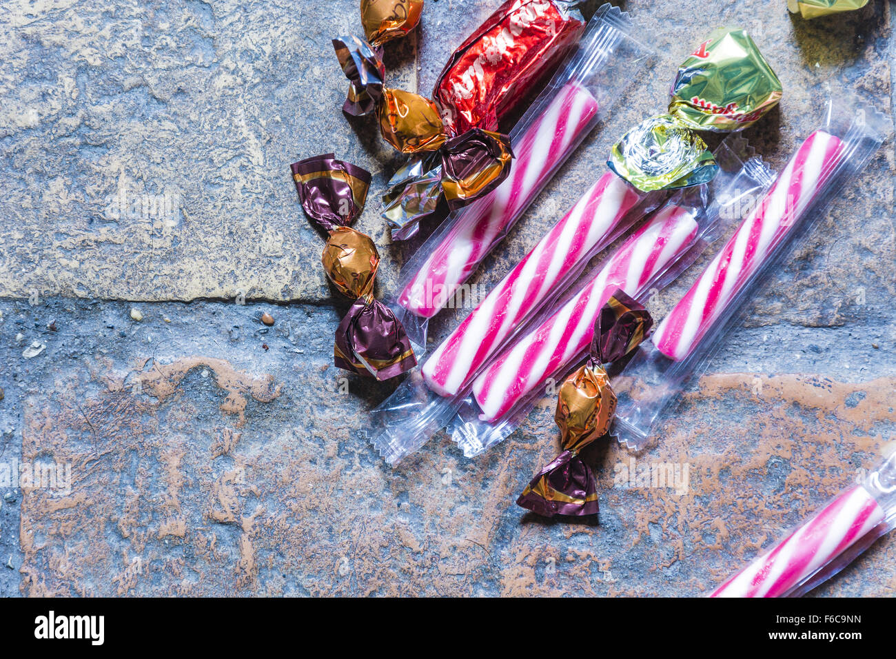 mixed candies on a rough bricked floor Stock Photo - Alamy