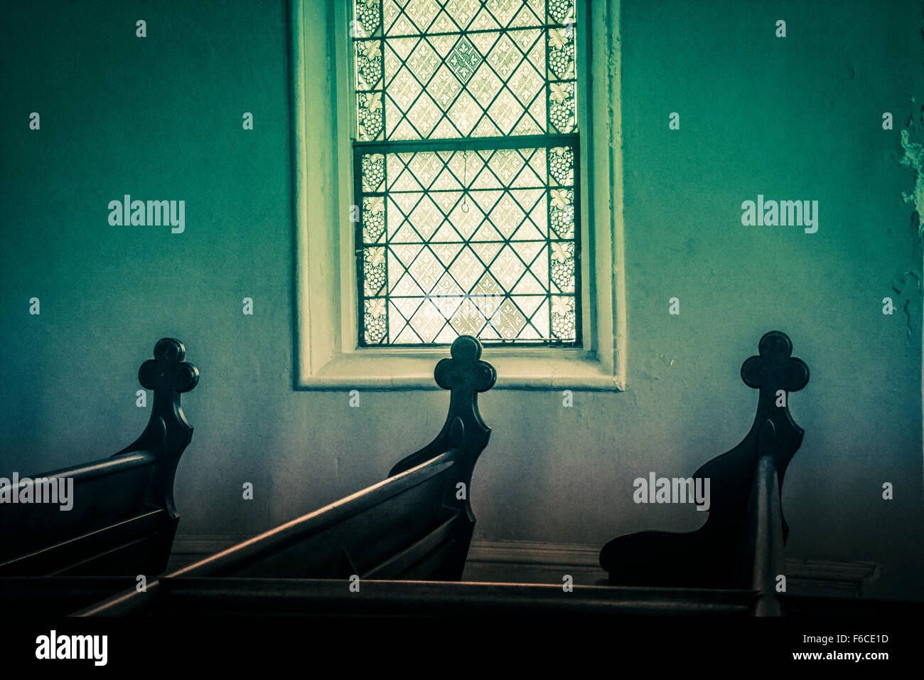 A dimly lit interior from a stained glass church window with carved ...