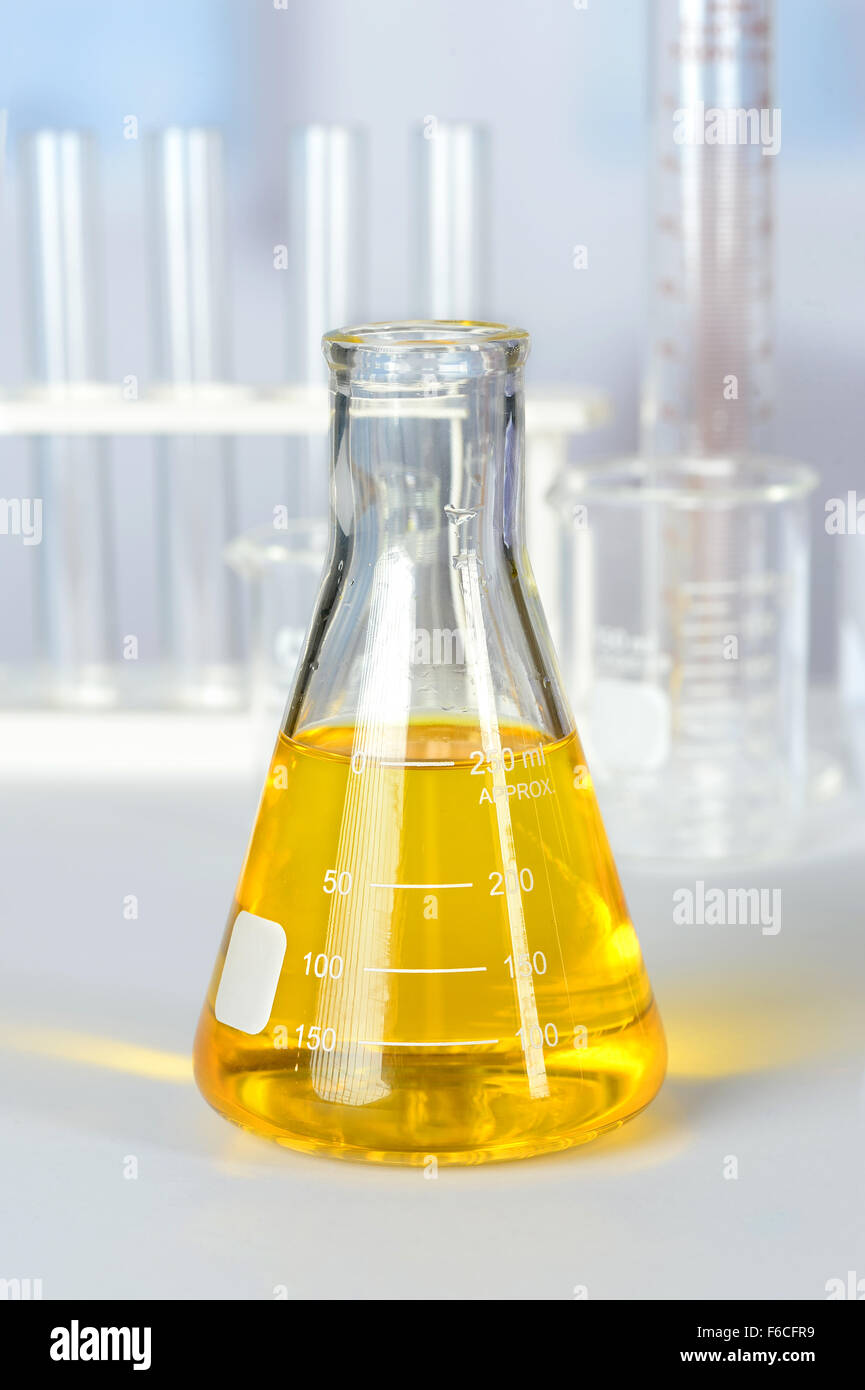 Beaker with yellow colorant on laboratory table Stock Photo - Alamy