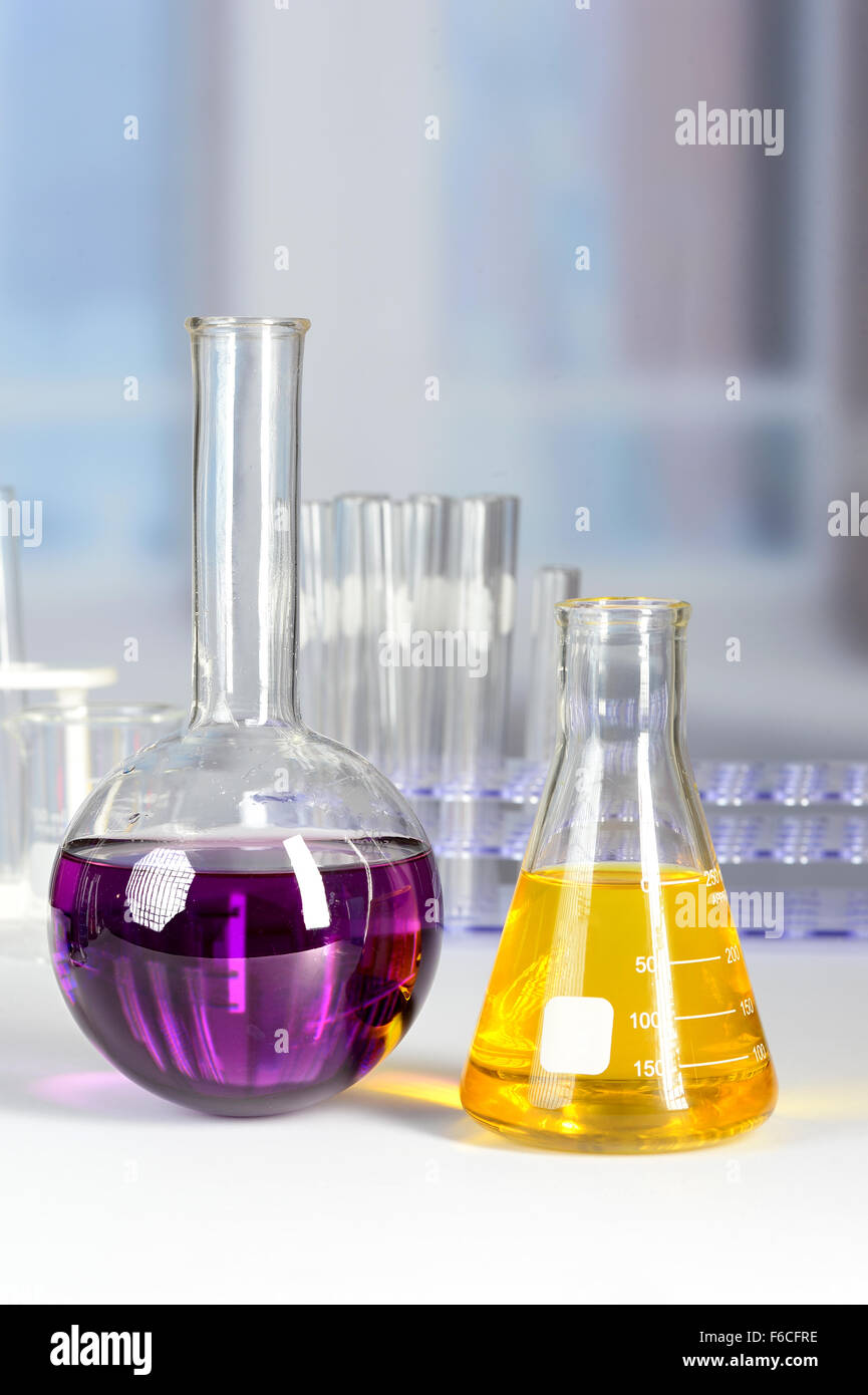 Laboratory flask and beaker with colored liquids over white table Stock ...