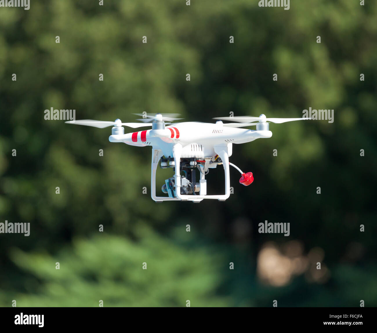 White drone quadcopter in flight with small camcorder Stock Photo - Alamy