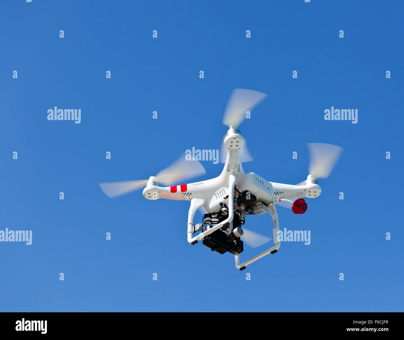 White drone quadcopter in flight with small camcorder Stock Photo - Alamy