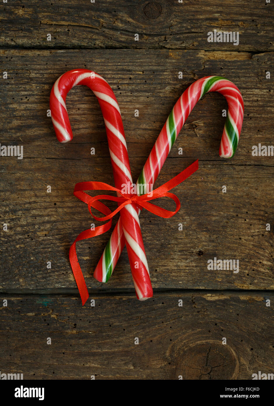 Closeup of two old fashioned candy canes on a rustic wooden background ...