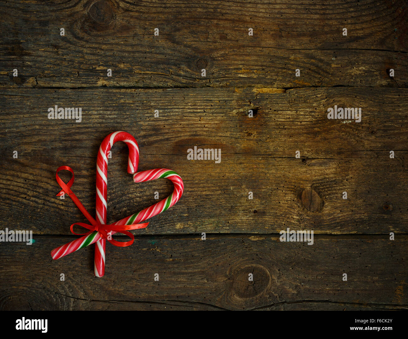 Candy canes in the heart shape on a wooden background Stock Photo - Alamy