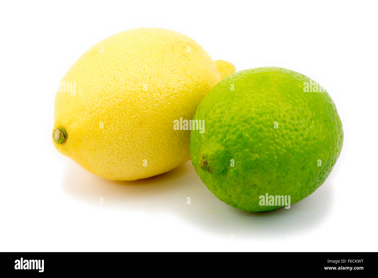 A single lemon and single lime isolated against a white studio ...