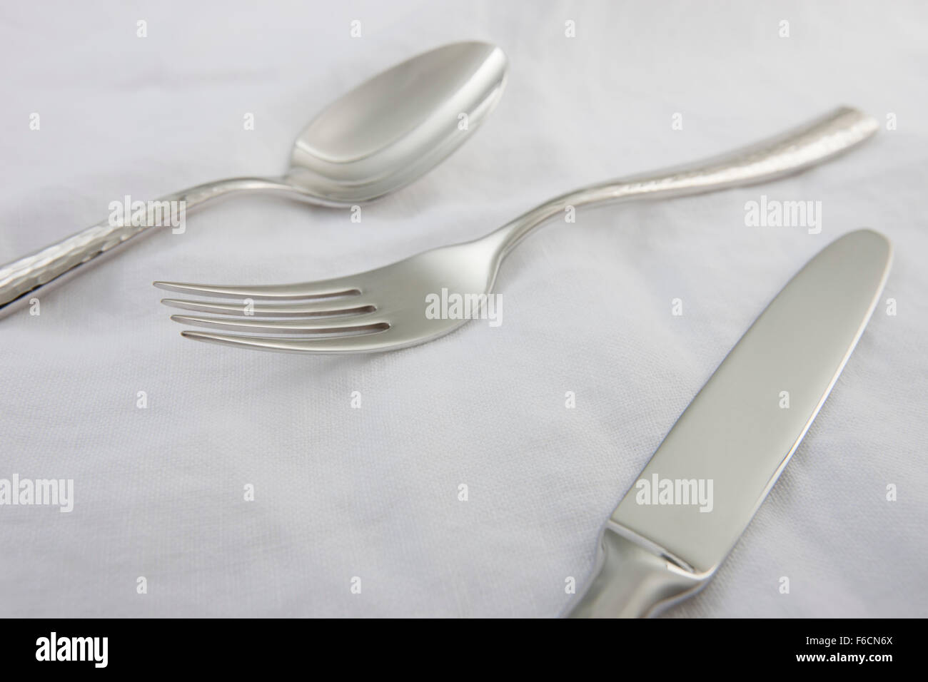 Still life photograph of silverware on a white table cloth Stock Photo ...