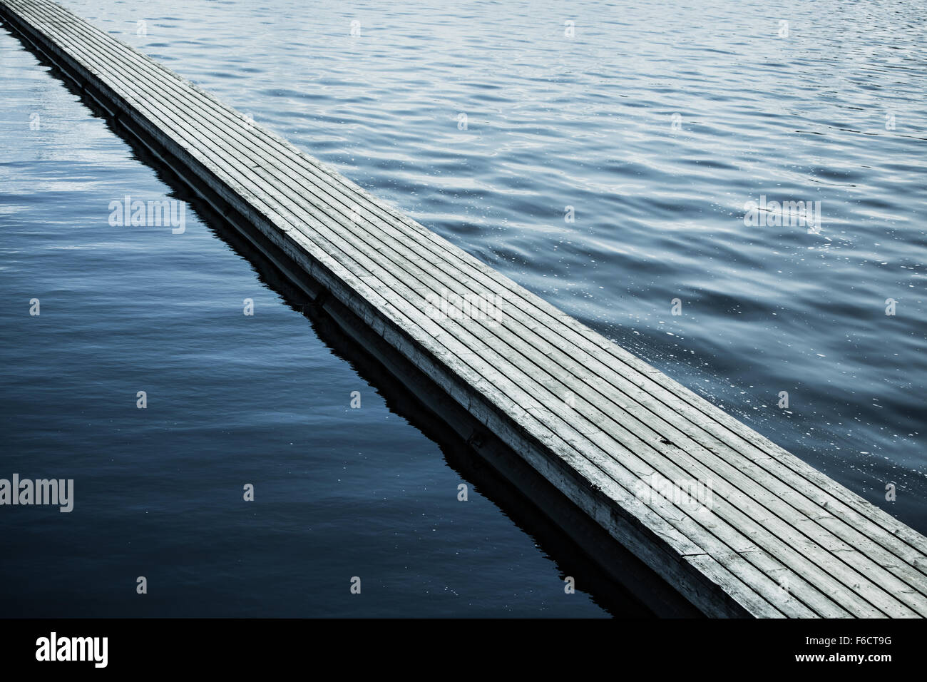 Long floating wooden bridge on water surface. Diagonal composition ...