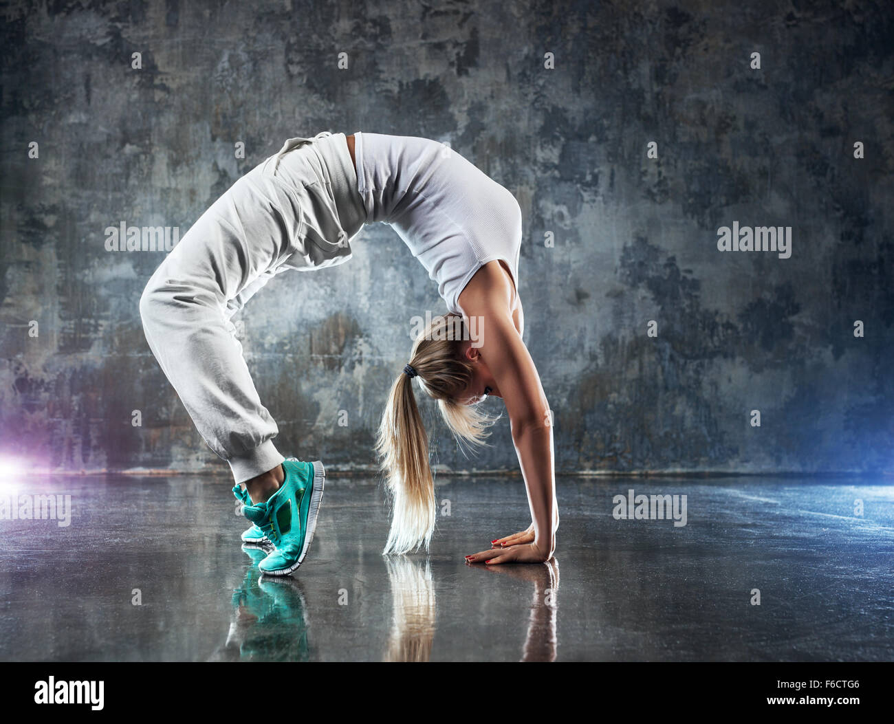 Young woman modern dancer. On dark stone wall background Stock Photo ...