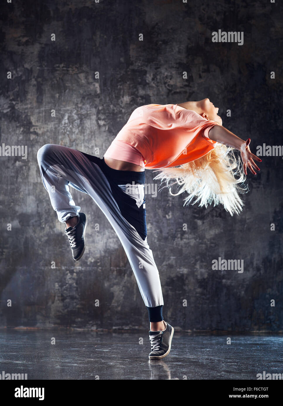 Young woman modern dancer. On stone wall background Stock Photo - Alamy