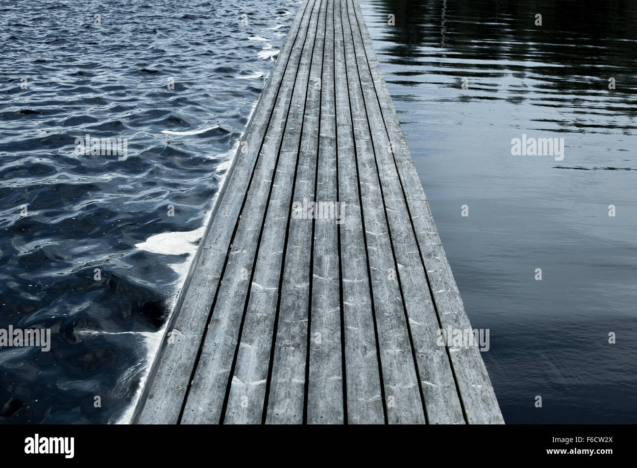Long floating wooden bridge on water surface Stock Photo - Alamy