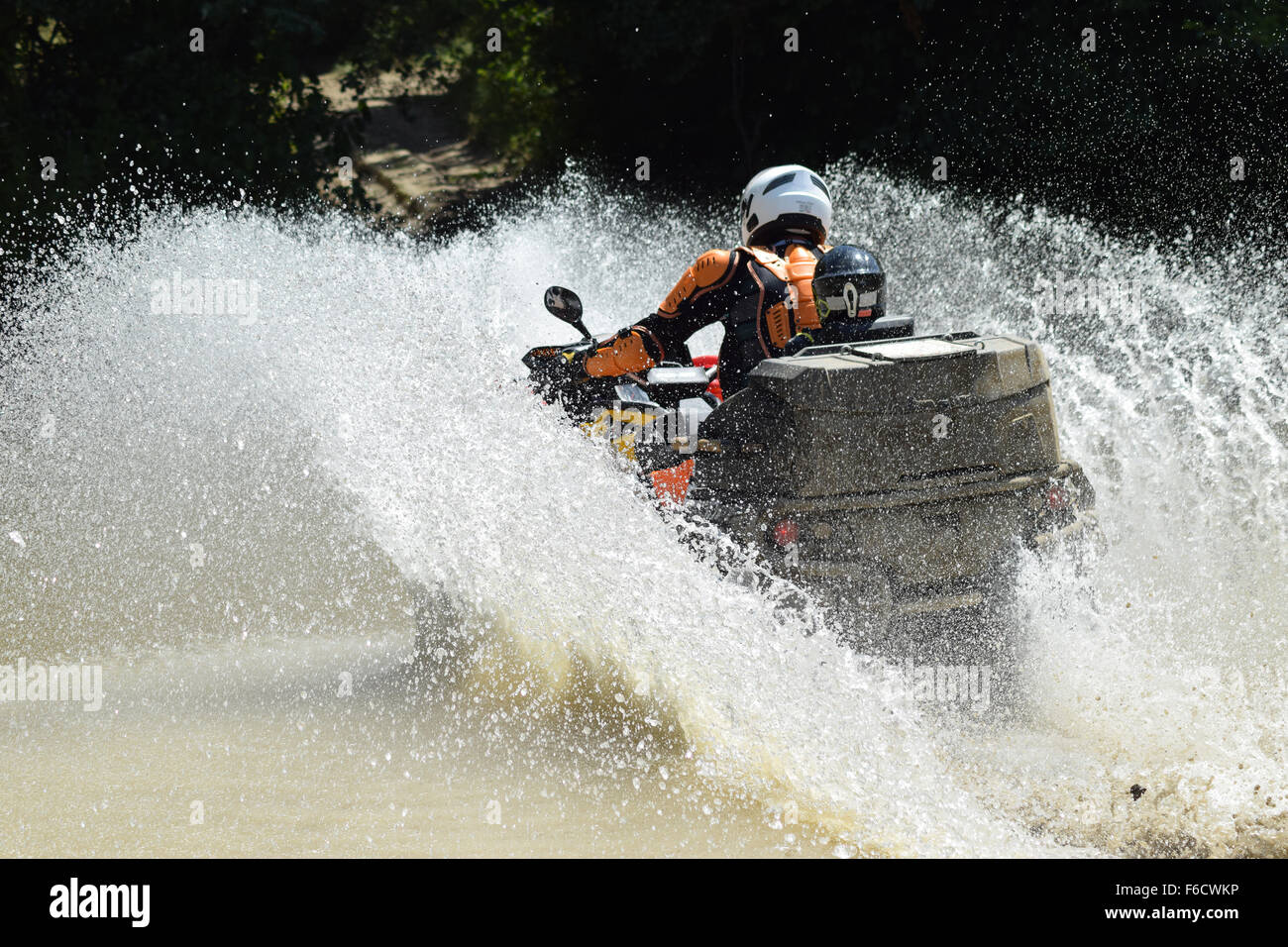 The man on the ATV crosses a stream. Tourist walks on a cross-country ...