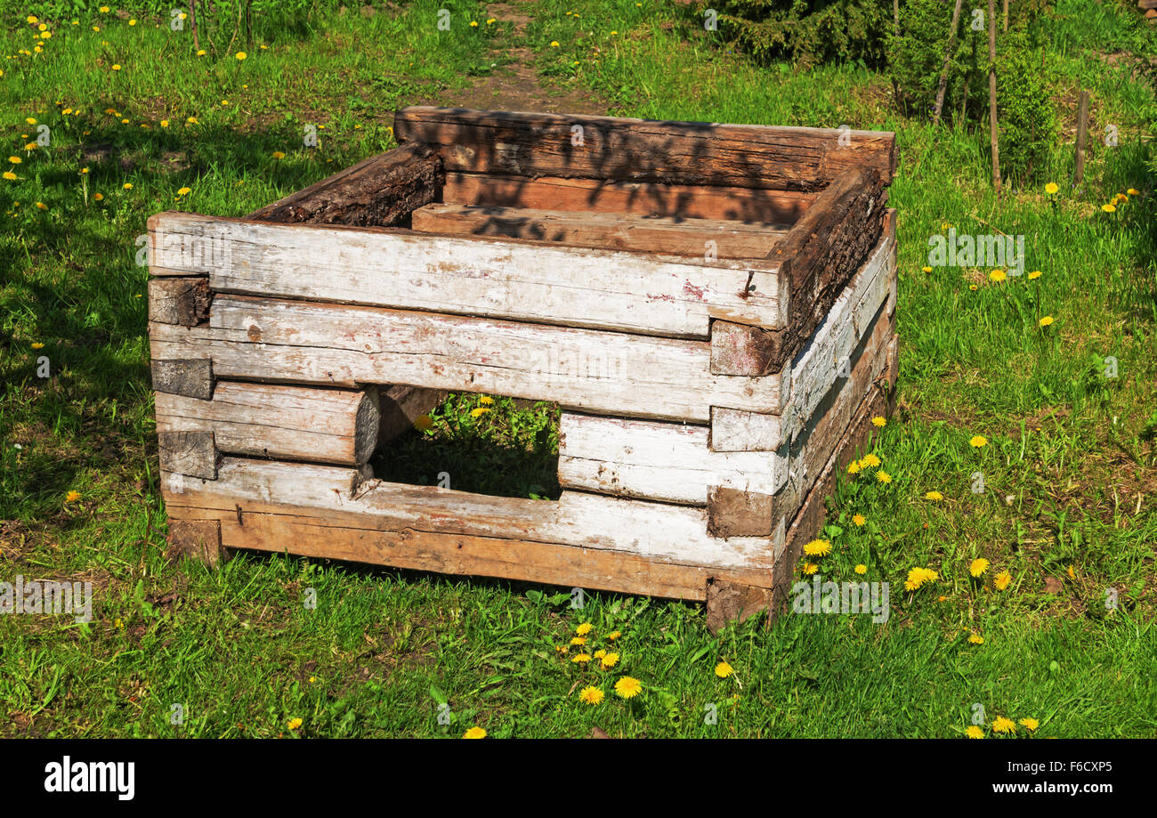 Spring. Old log cabin - wooden base for furnace. Furnace inside wooden ...