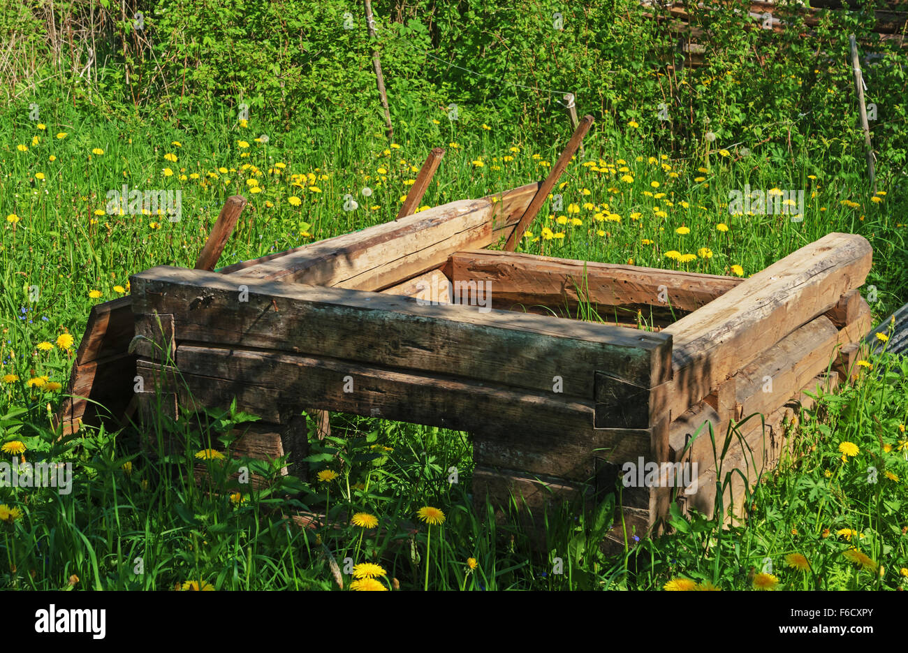 Spring. Old log cabin - wooden base for furnace. Furnace inside wooden ...