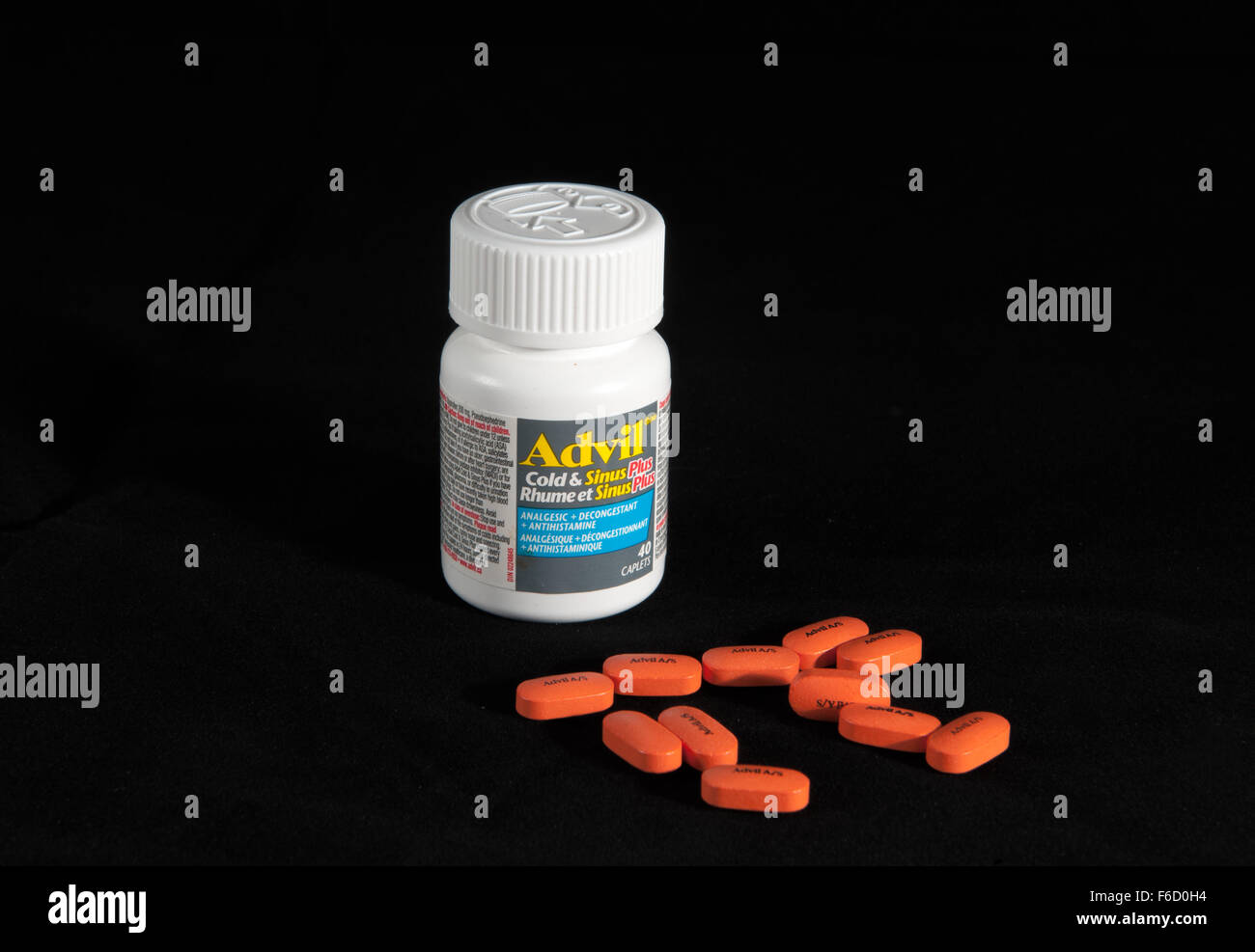 A container of Advil and tablets against a black background Stock Photo ...