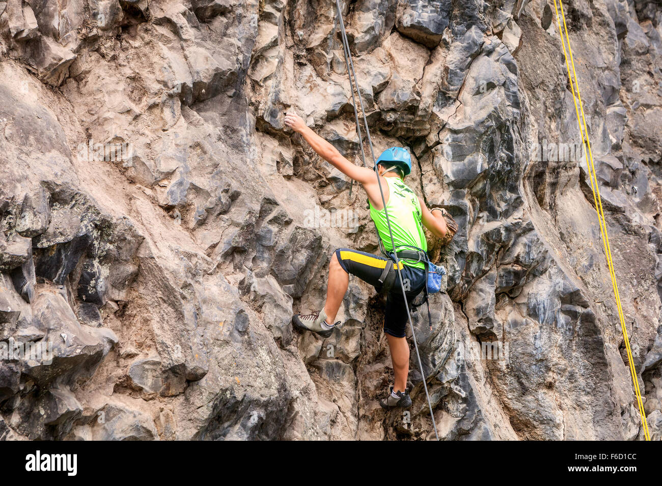 Young man climbing cliff wall hi-res stock photography and images - Alamy
