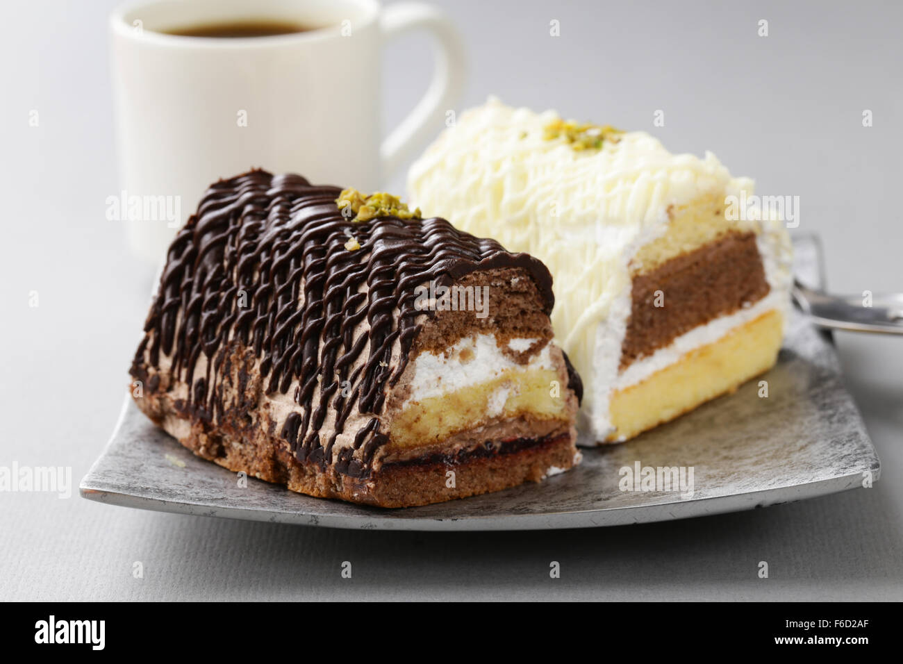 portioned dessert piece of cake with cream and chocolate on a plate ...