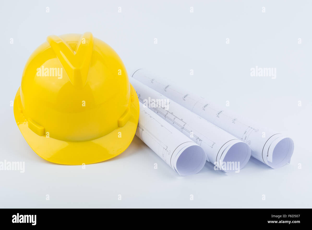 Yellow safety helmet and Scrolls of engineering drawings Stock Photo ...