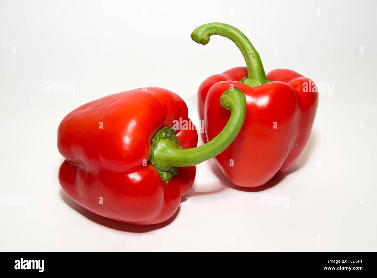 Two red peppers on a white background Stock Photo - Alamy