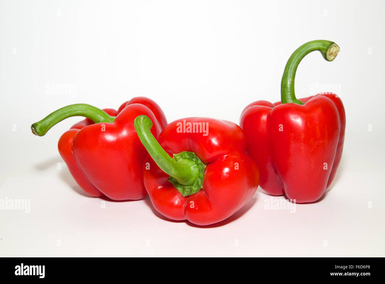 Three red peppers on a white background Stock Photo - Alamy