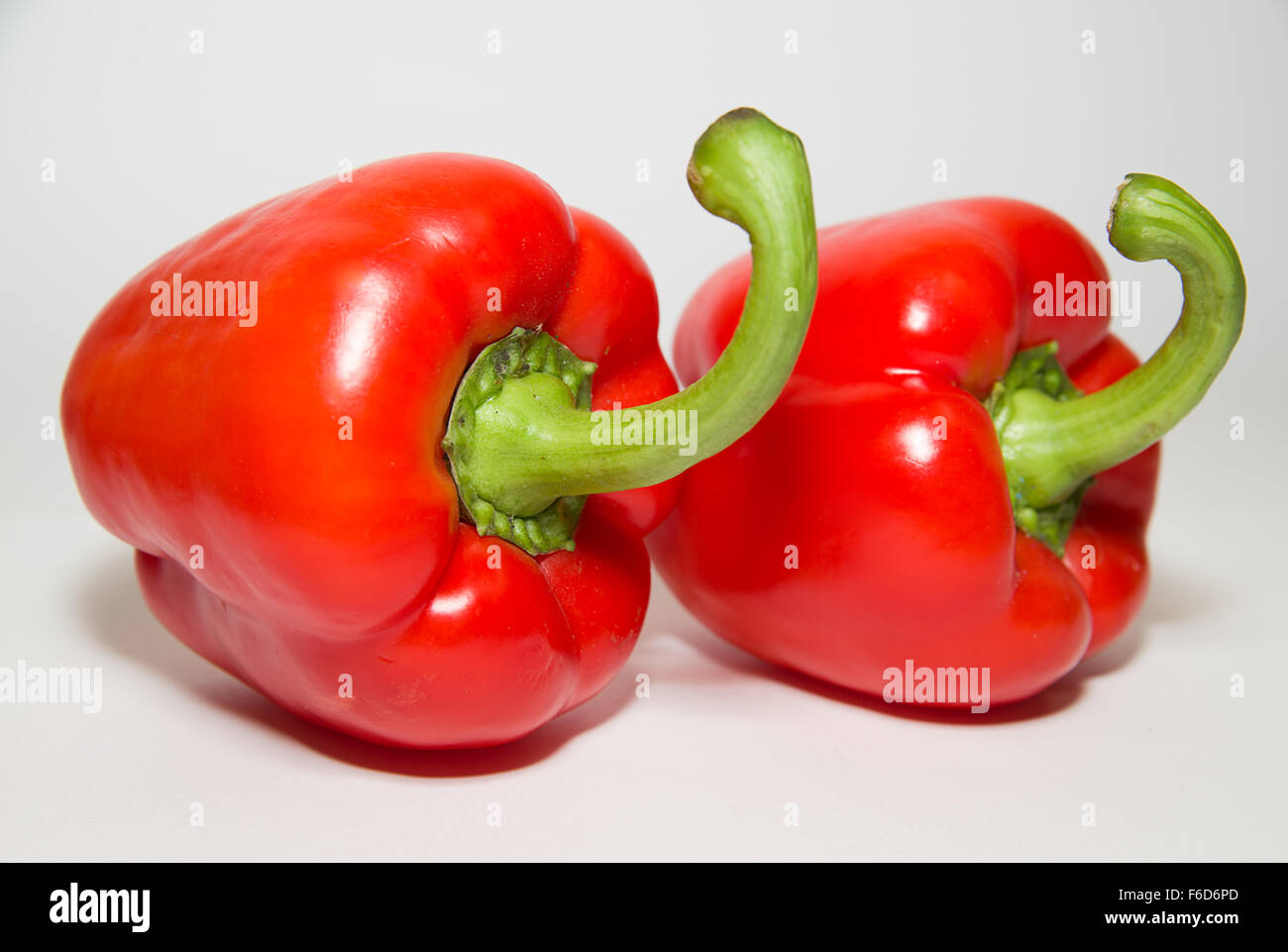 Two red peppers on a white background Stock Photo - Alamy