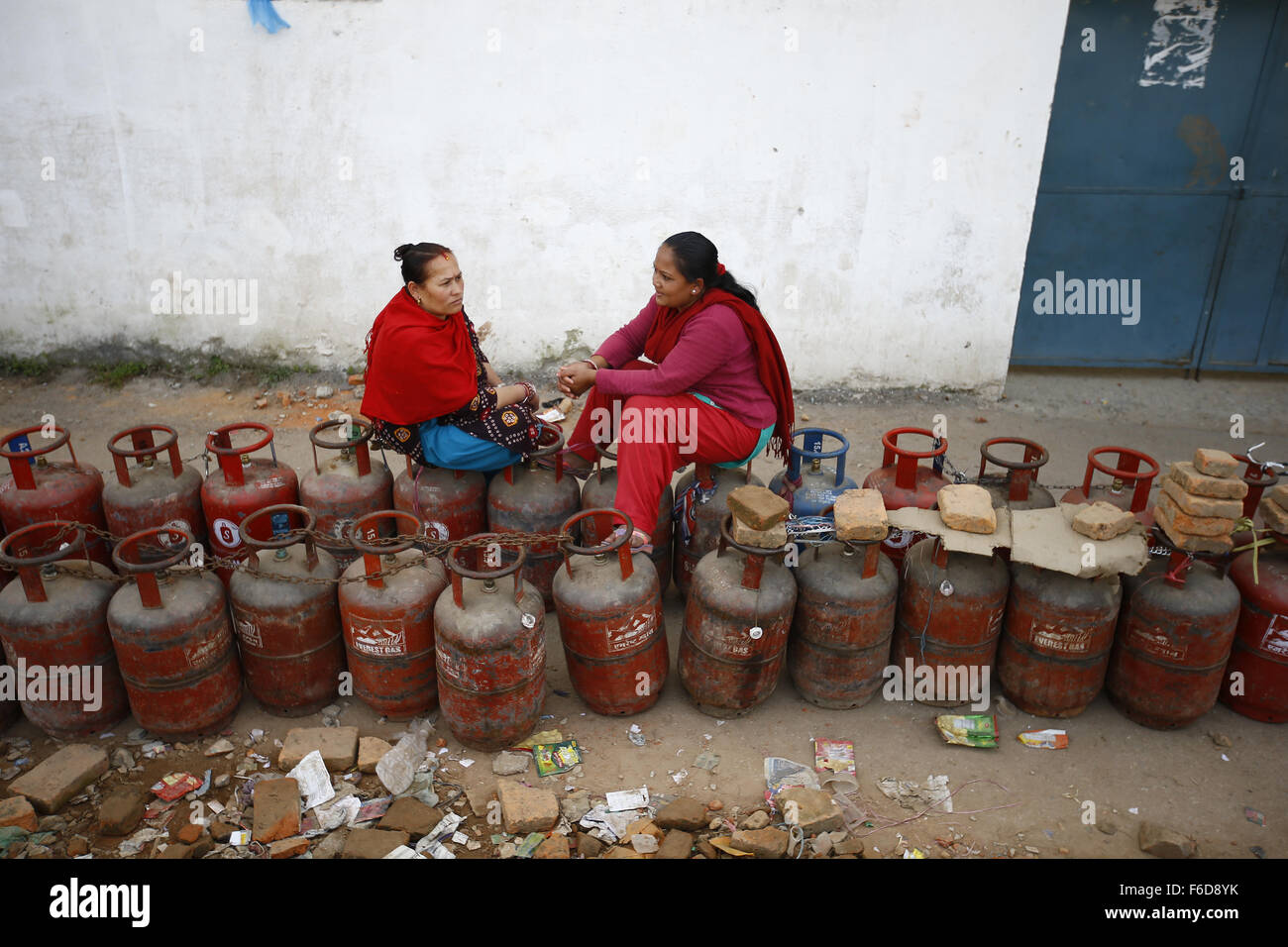 Nepalese women sit on top of empty cooking gas cylinders waiting for ...