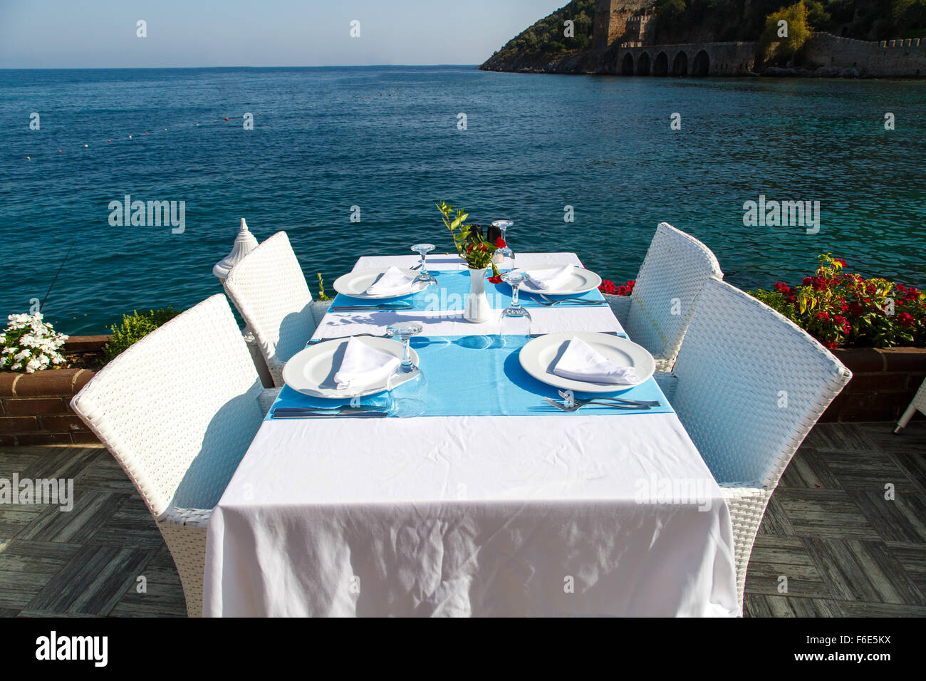 Front view of dinner table with white plates for four on a table with ...