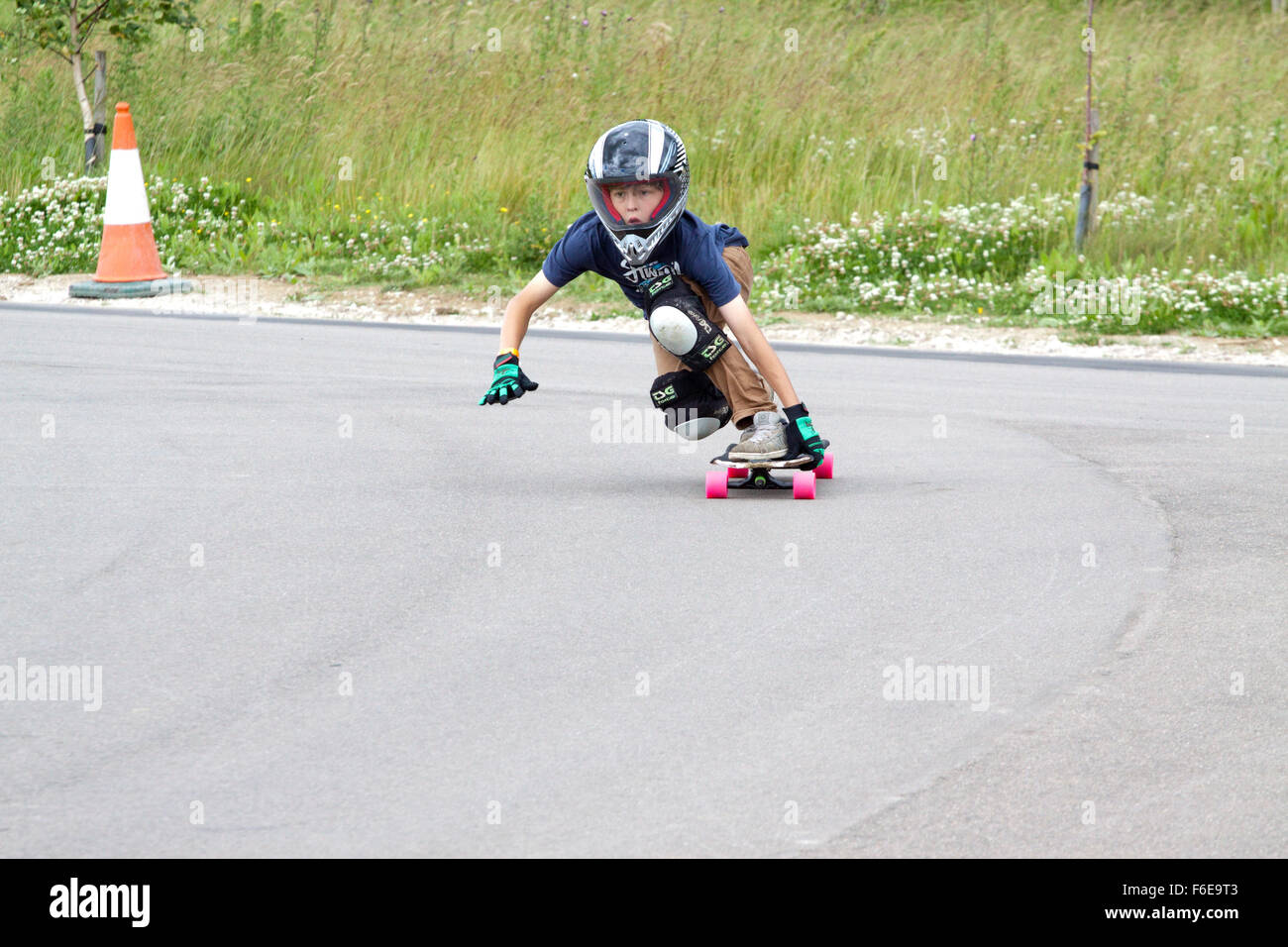 Skateboarder racing downhill lean to take a right hand bend Stock Photo ...