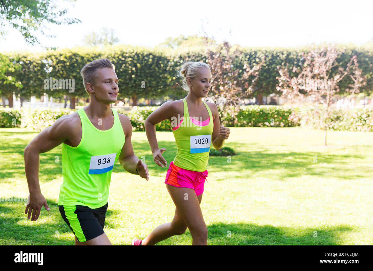 happy sportsmen couple racing wit badge numbers Stock Photo - Alamy