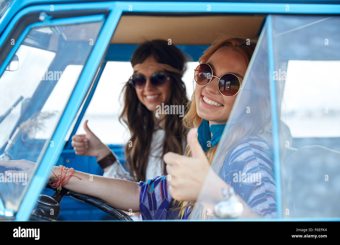 smiling young hippie women driving minivan car Stock Photo - Alamy