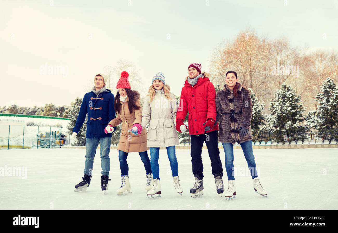 happy friends ice skating on rink outdoors Stock Photo - Alamy